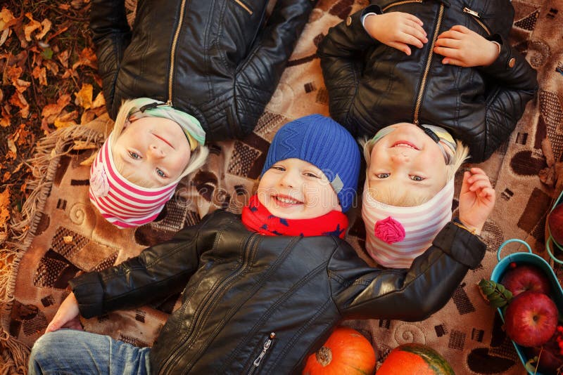 Three Smiling Friends Kids Lying in Autumn Leaves. Stock Image - Image ...