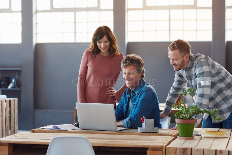 Smiling Young Coworkers Using a Laptop Together in an Office Stock ...