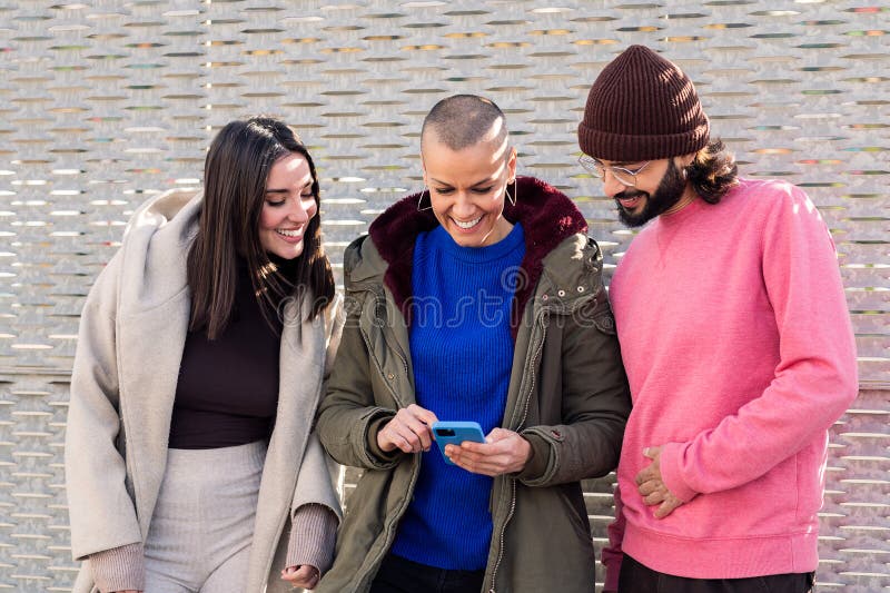 Three Smiling Young Friends Enjoying Using Phone Stock Photo - Image of ...