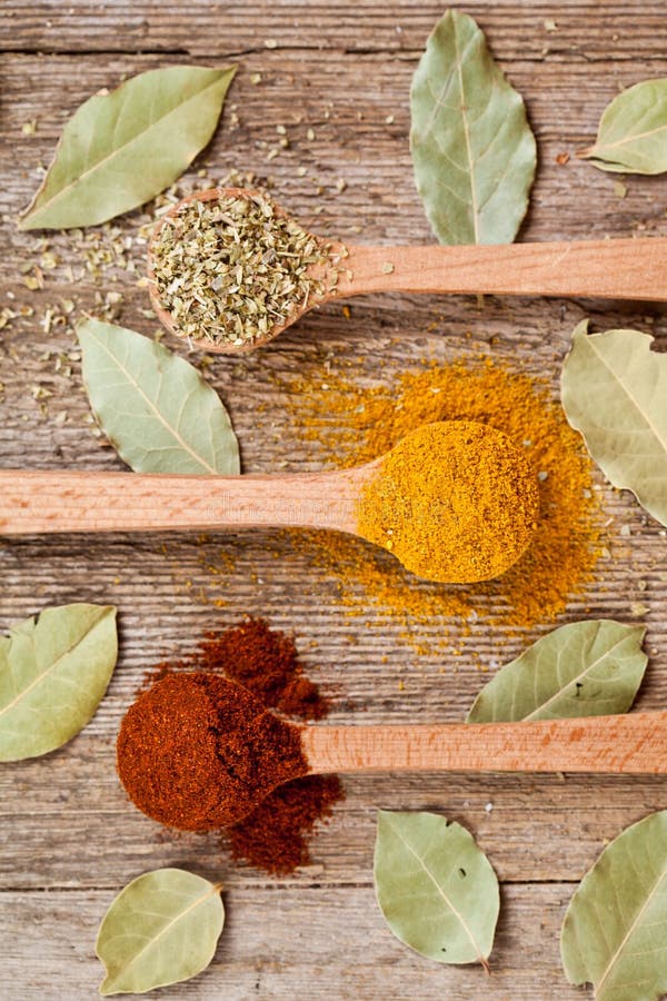Three Spices in Wooden Spoons and Bay Leaves Stock Image - Image of ...