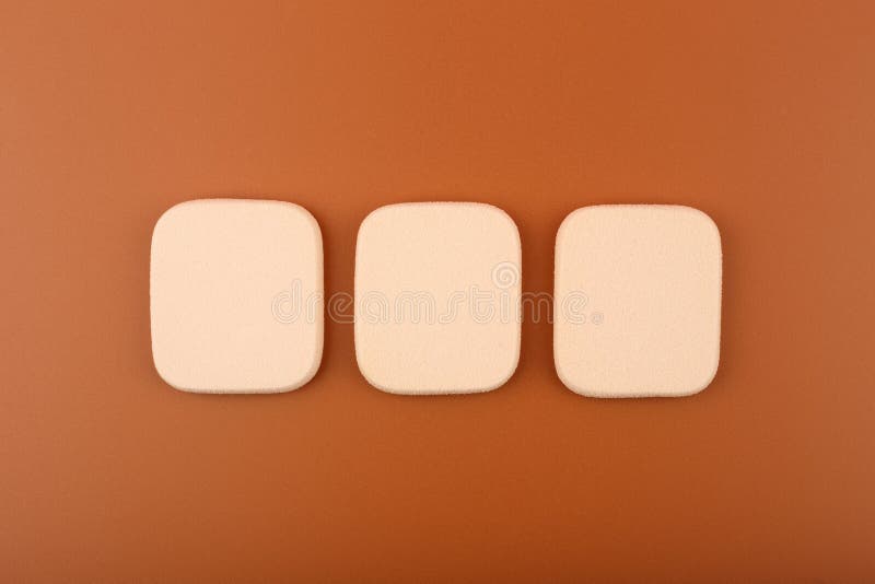 Three Square Shaped Make Up Sponges on Brown Background Stock Image ...