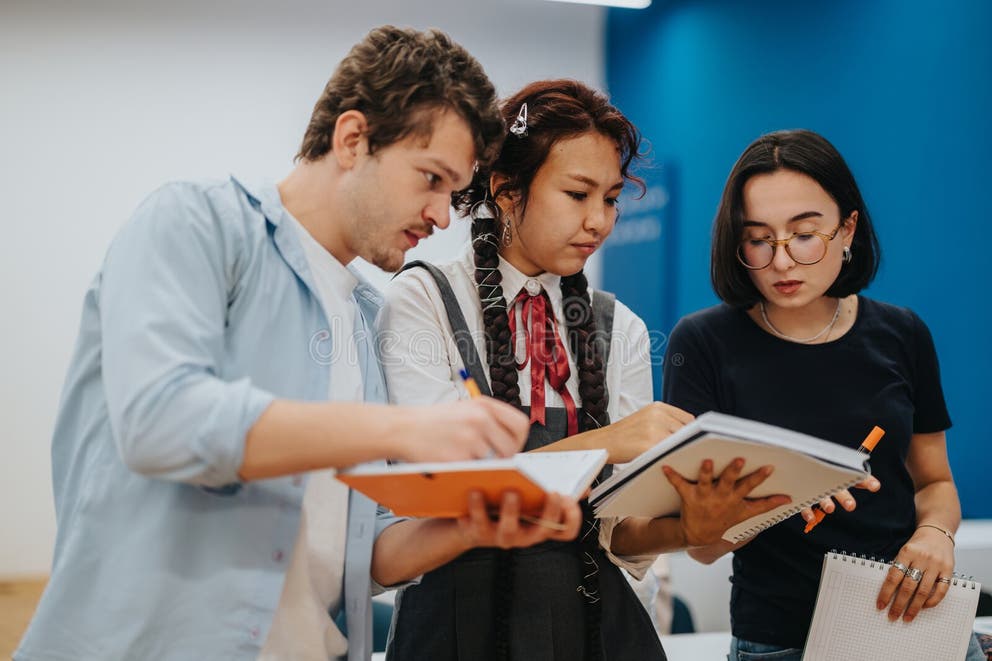 Three Students Collaborating on a Group Project in a Classroom Stock ...