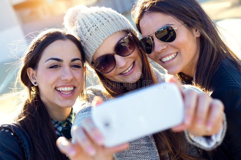 Three Students Girls Using Mobile Phone in the Campus. Stock Image ...