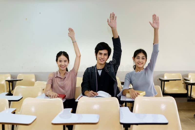 Three Students Raised Their Hands Together in the Classroom. Stock ...