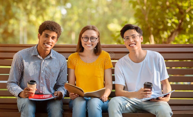 Three Students Sitting on Bench Relaxing Having Coffee Outdoor Stock ...