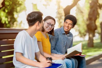 Three Students Talking Discussing Classes Relaxing Sitting on Bench ...