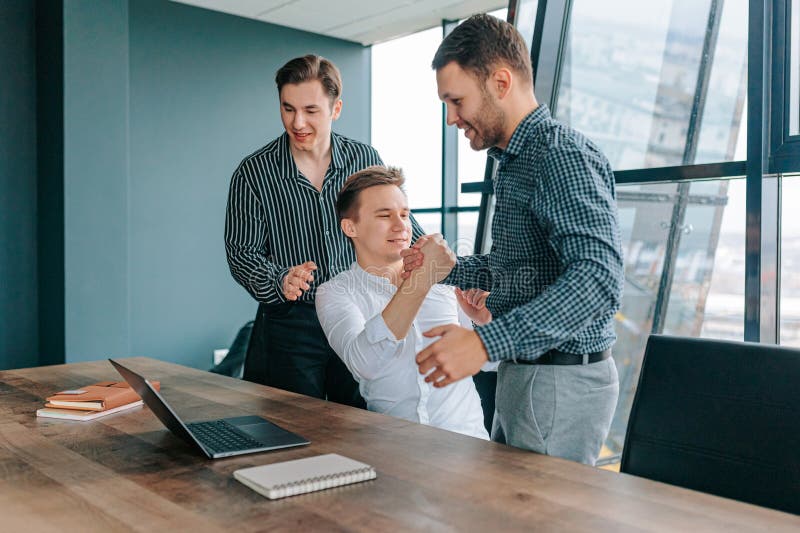 Three Successful Male Coworkers Collaborating on a Project with Their ...