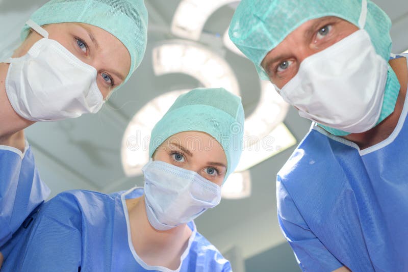 Three Surgeons at Work Operating in Surgical Theatre Stock Photo ...