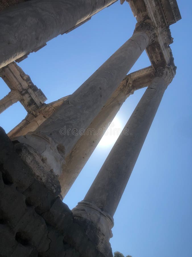Three Columns Standing in Front of a Blue Sky and Sun Stock Photo ...