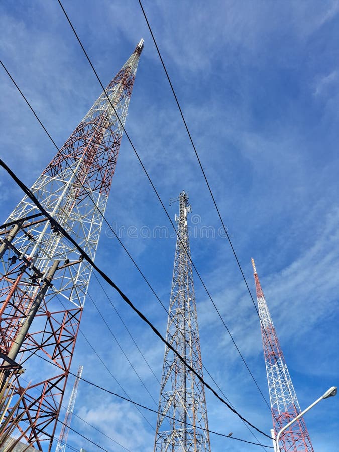 Three Telecommunications Tower Poles Against a Bright Blue Sky in the ...