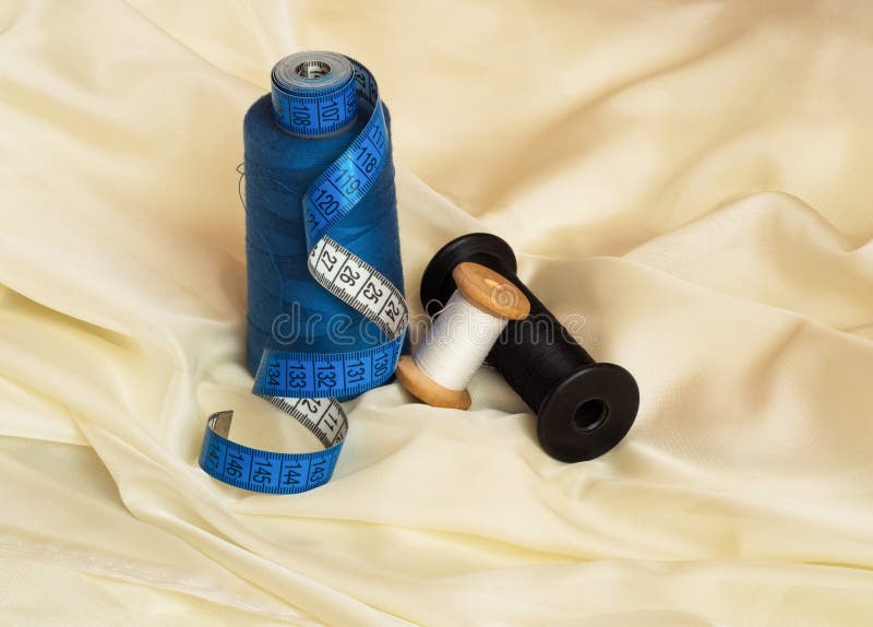 Three Threads of Different Colors and Blue Twisted Tape Measure on ...