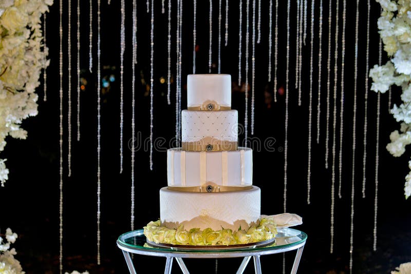 Three Tiered Wedding Cake Sitting on Top of Glass Cake Stand Stock ...