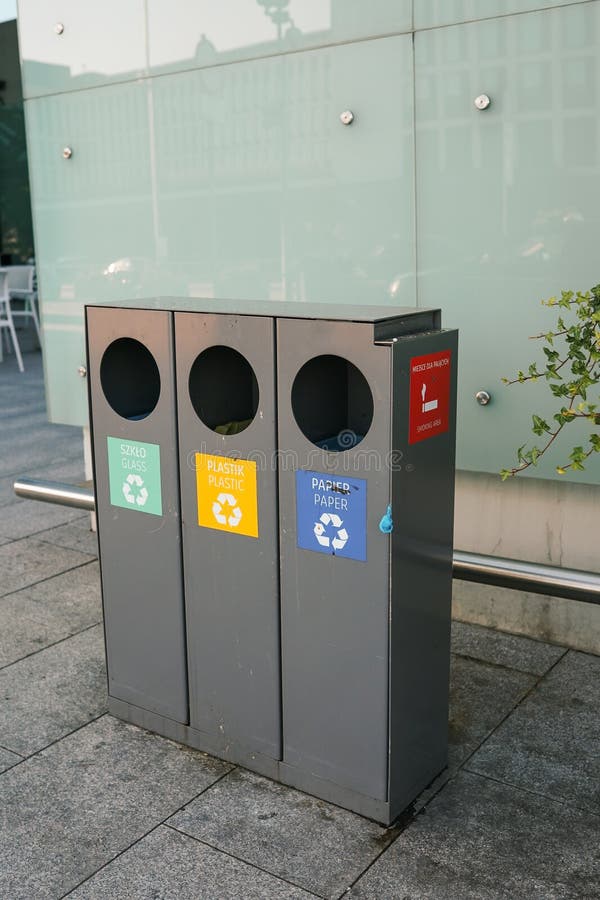 Three Trash Cans are Lined Up on a Sidewalk, with One of Them Being ...