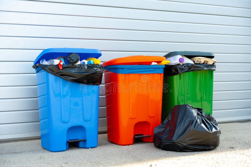 Three Trash Containers Full of Garbage Near the Building Stock Photo ...