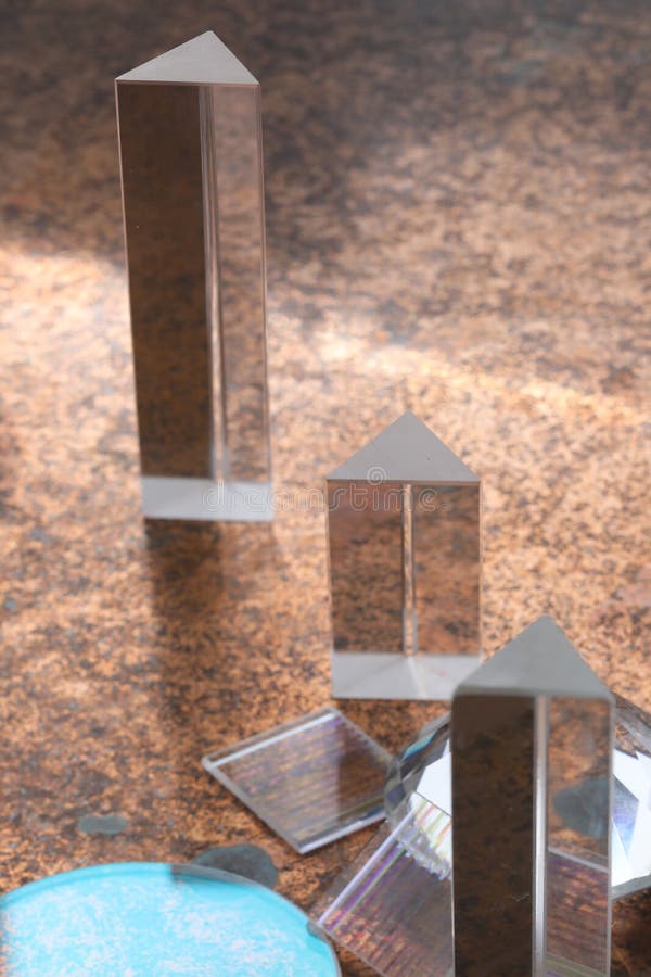 Three Triangular Glass Objects are on a Brown Surface Stock Photo ...