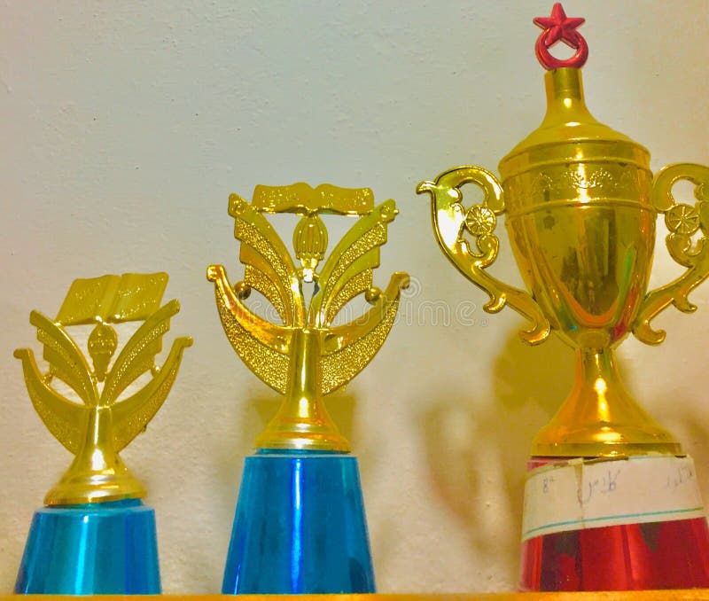 Three Trophies are Displayed Against a Plain Backdrop. Stock Photo ...