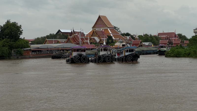 Three Tugboats Work Together, Pulling a Massive Cargo Ship Down the ...