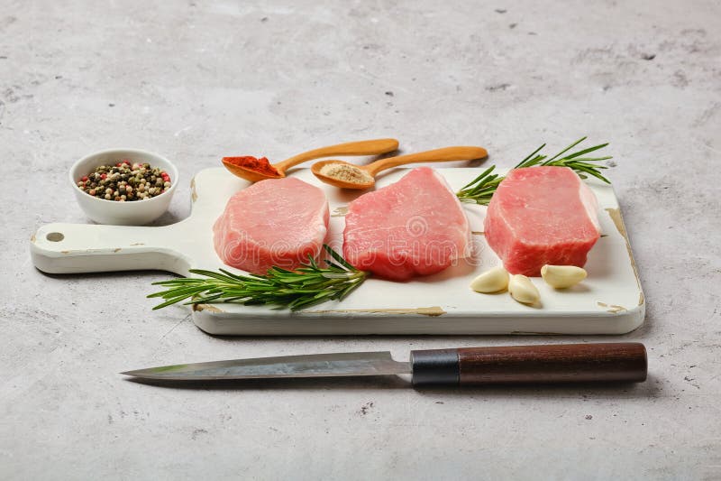Three Uncooked Pork Cutlets on Cutting Board Stock Image - Image of ...