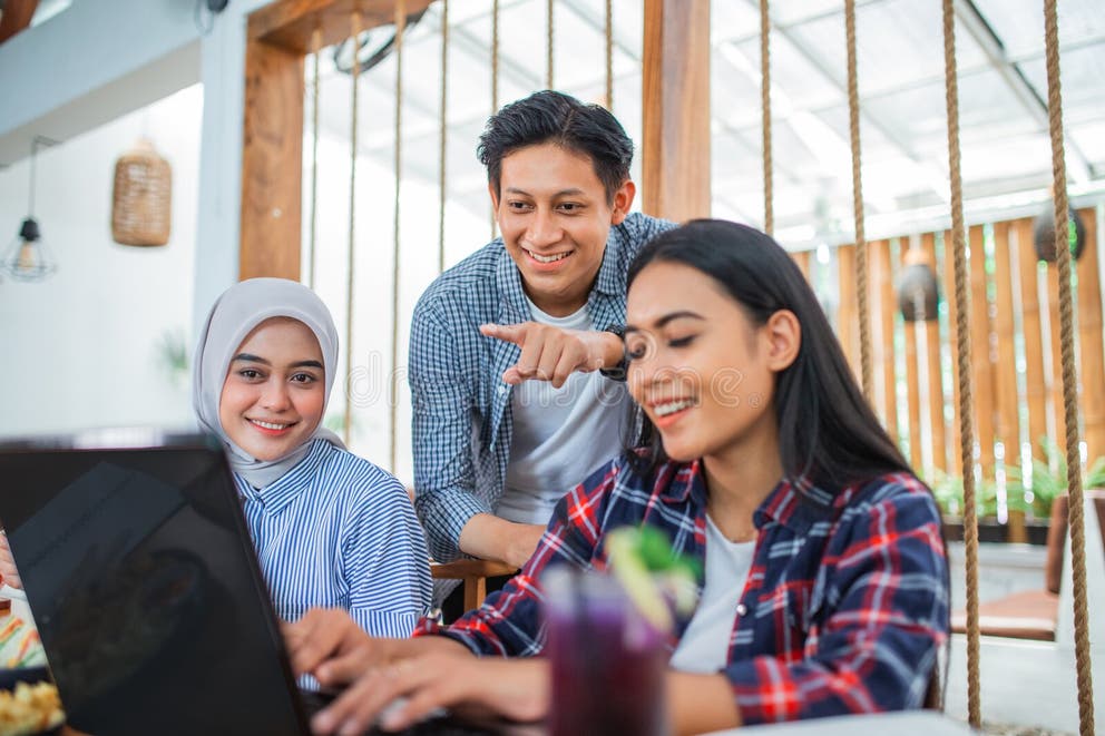 Three University Students Use a Shared Laptop during Group Work with ...