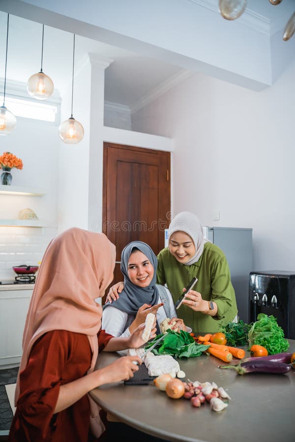 Three Veiled Women Use Cell Phones while Cooking Together Stock Image ...