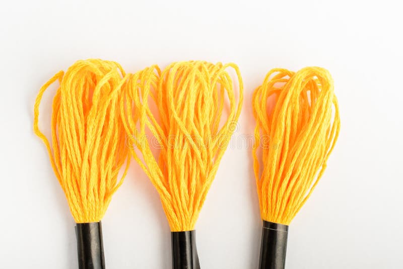 Three Vivid Yellow Sewing Threads for Embroidery Isolated on a White ...