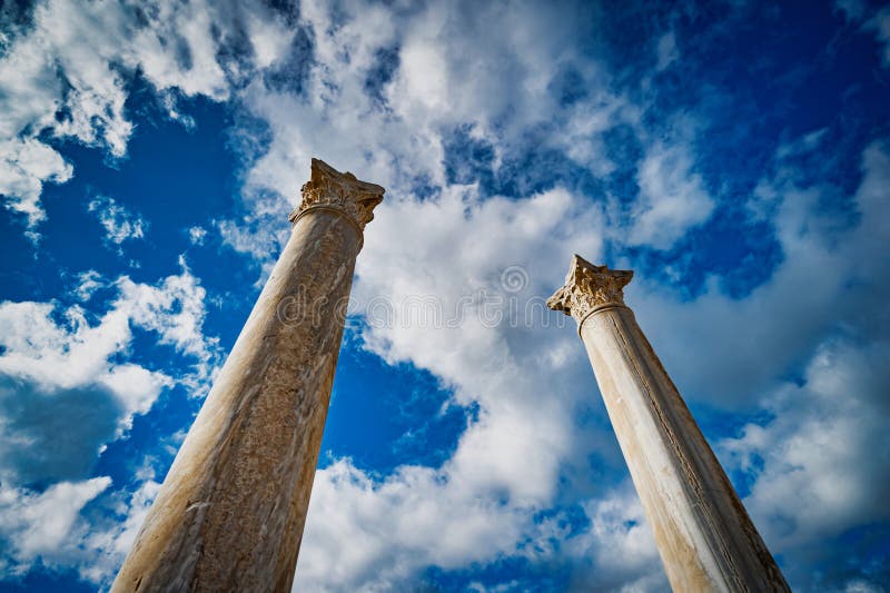 An Ancient Ruin with Three Columns and Some Clouds in the Background ...