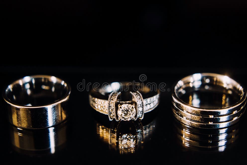 Three Wedding Rings on a Mirror Surface Stock Image - Image of gold ...