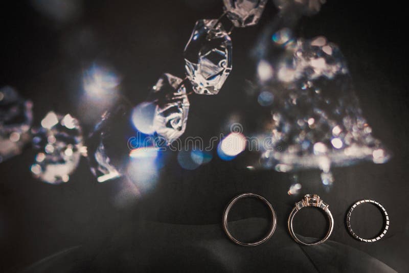 Three Wedding Rings on a Shiny Background Stock Image - Image of ...