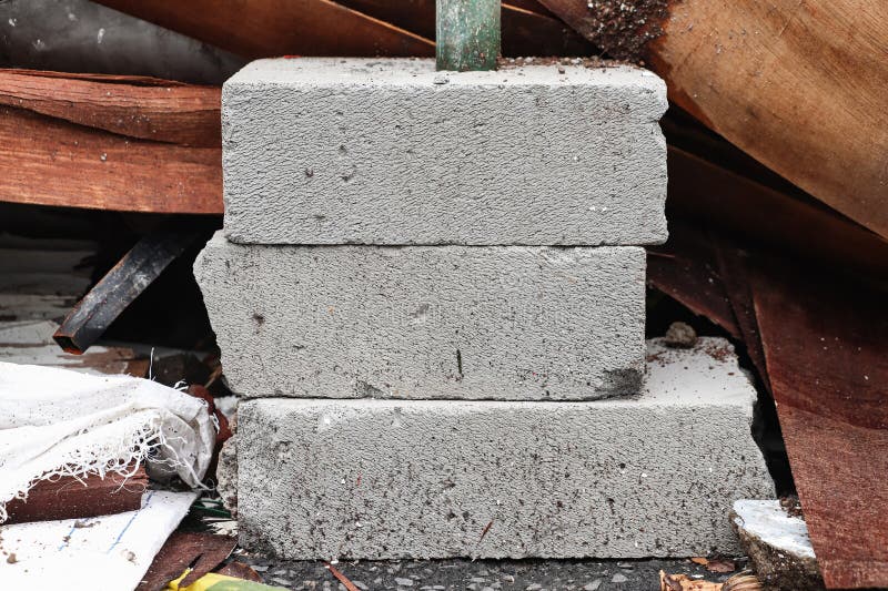 Three White Bricks Stacked on Asphalt To Support Green Iron Rods Stock ...
