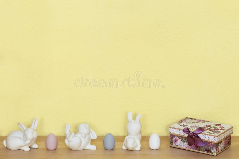 Three White Rabbits and Three Easter Eggs with a Gift Stock Photo ...