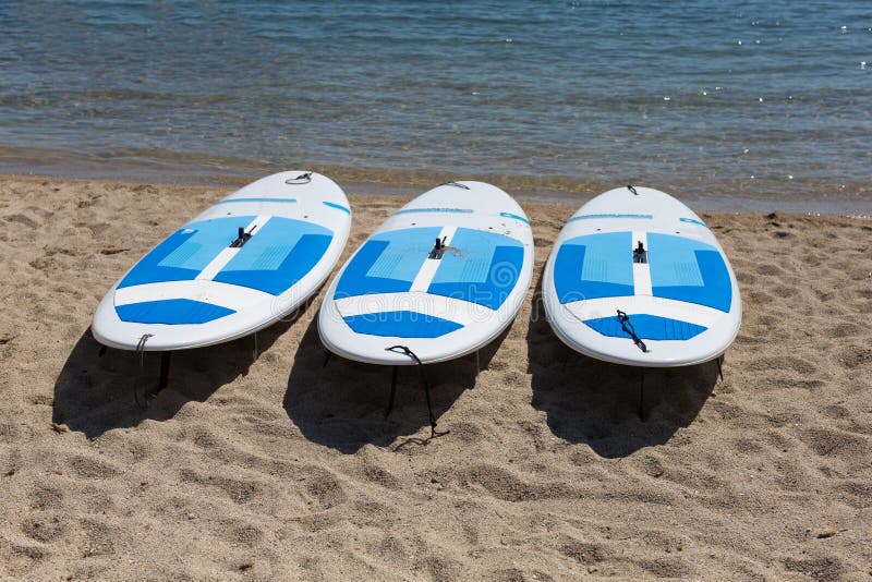 Three White Surfboards Resting on the Shoreline on the Beach Stock ...