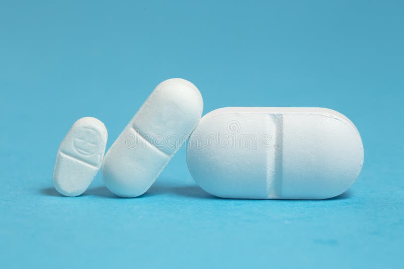 Three White Pills of Different Sizes on Blue, Dosage Stock Image ...