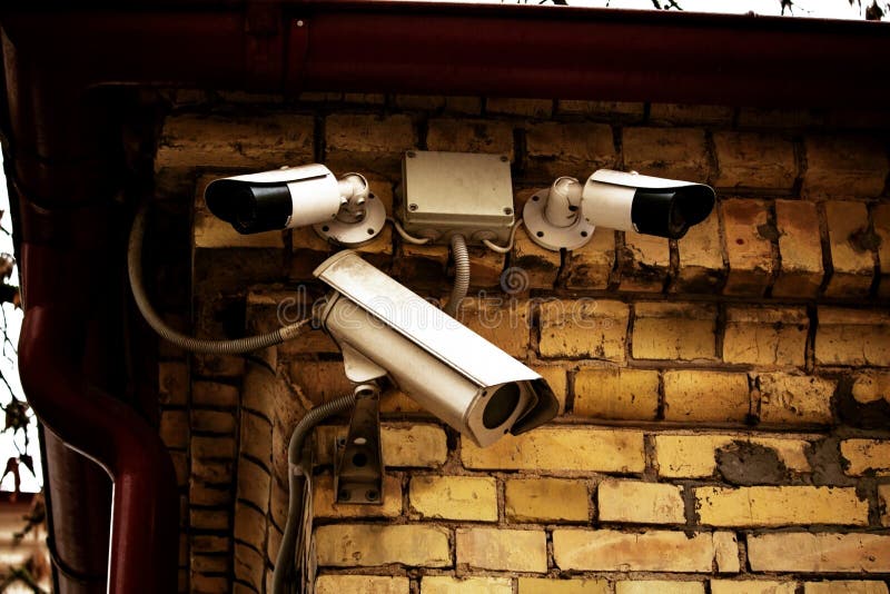Three White Video Cameras on Yellow Brick Wall Stock Photo - Image of ...