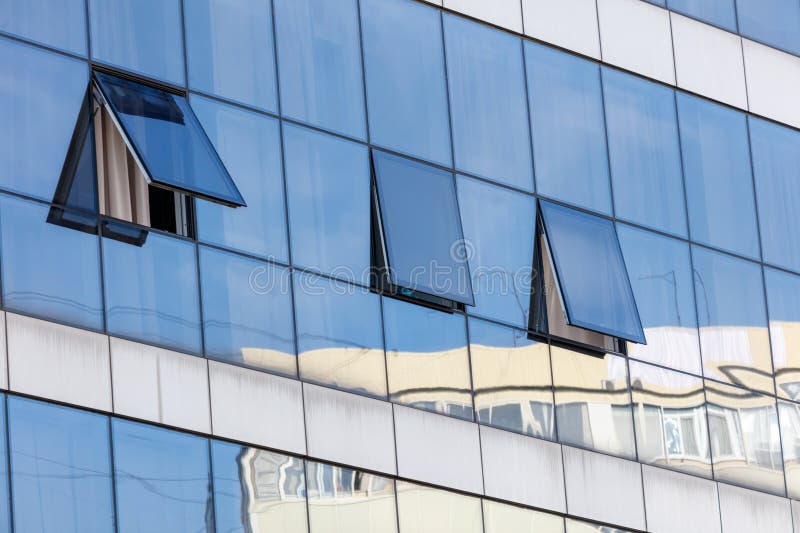 Three Windows on a Building with a Reflection of the Building in the ...