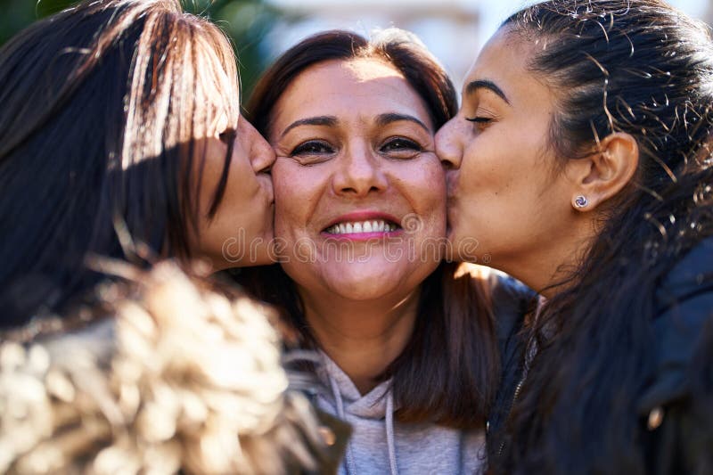 Three Woman Mother And Daughters Standing Together And Kissing At Park