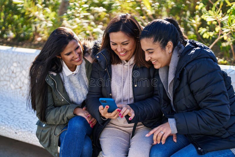 Three Woman Mother and Daughters Using Smartphone Sitting on Bench at ...