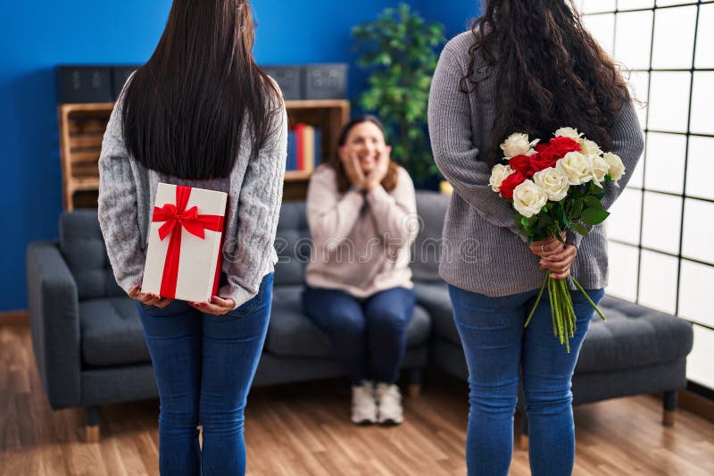 Three Woman Surprise with Gift and Flowers on Back at Home Stock Photo ...