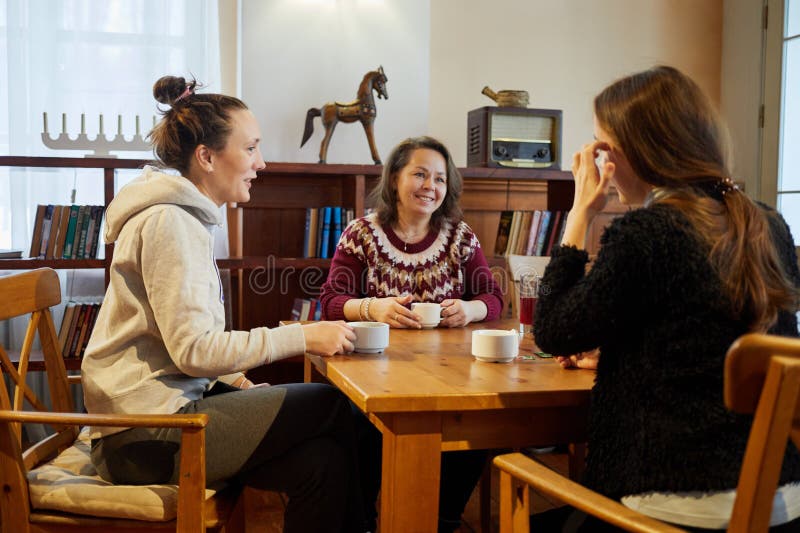 Three Women of Different Ages Sit at Table Talking Stock Photo - Image ...