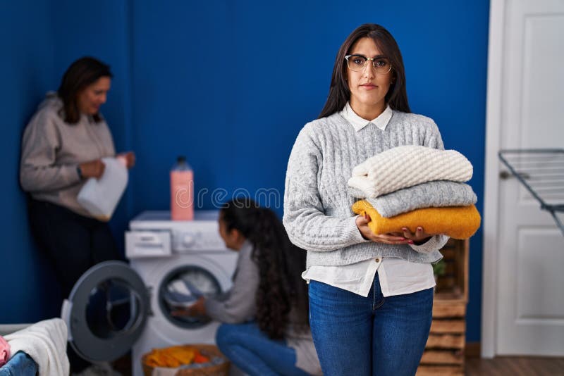 Three Women Doing Laundry at Home Relaxed with Serious Expression on ...