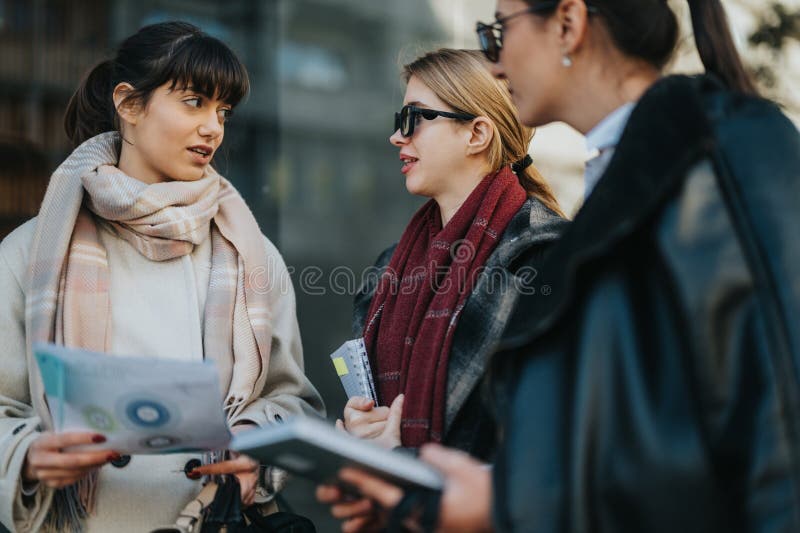 Three Women Discussing Business Papers during an Outdoor Casual Meeting ...
