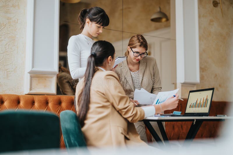 Three Female Professionals Collaborating on a Business Presentation ...