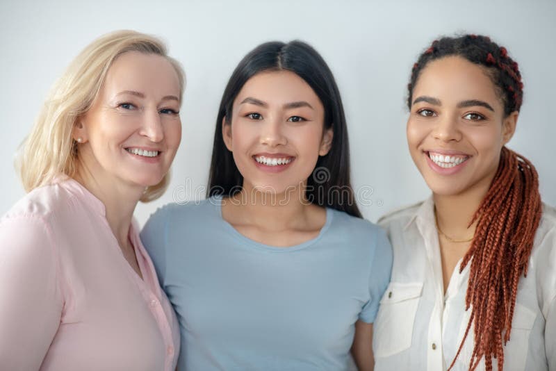 Three Women Standing Near the Wall Smiling Nicely Stock Photo - Image ...