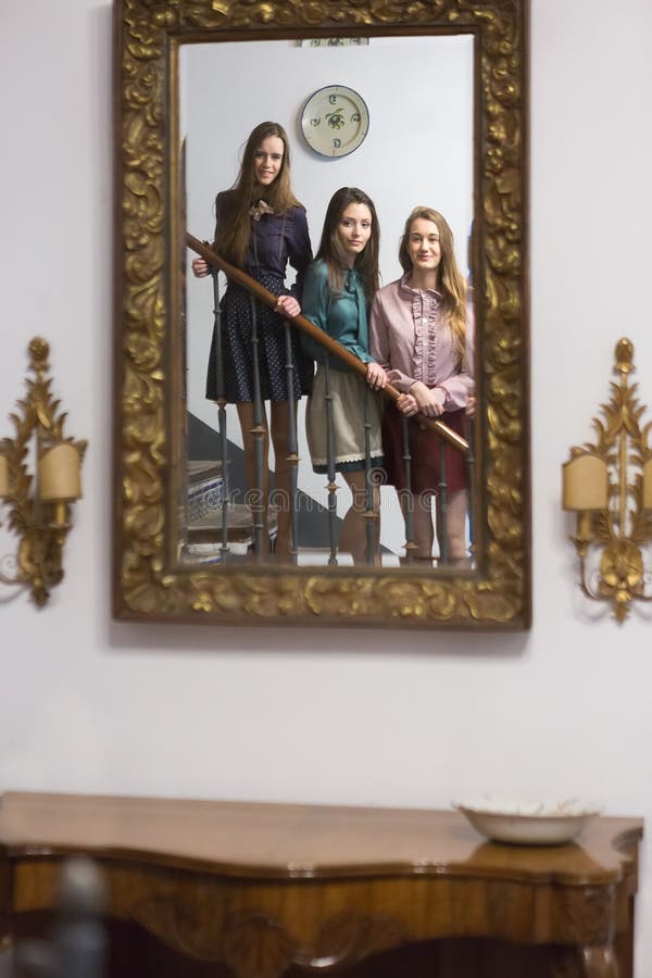 Three Women on Steps Looking in Mirror Stock Image - Image of lamp ...
