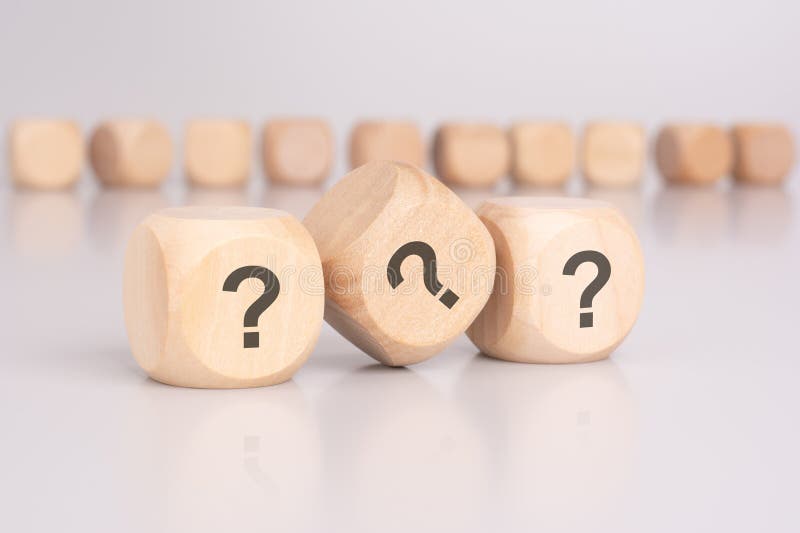Three Wooden Blocks with Question Marks Over a Brown Background with ...