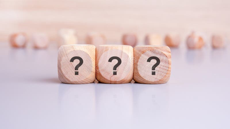 Three Wooden Blocks with Question Marks Over a Brown Background with ...