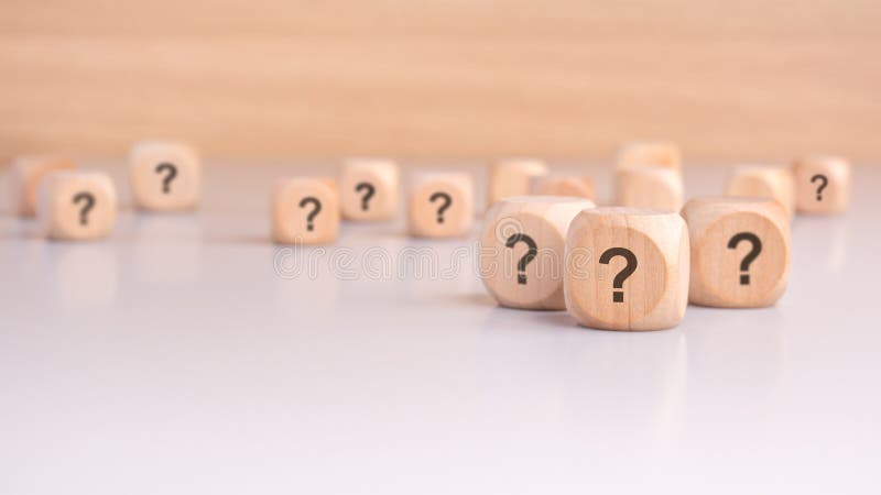 Three Wooden Blocks with Question Marks Over a Gray Background with ...