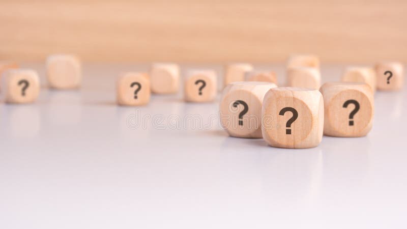 Three Wooden Blocks with Question Marks Over a Gray Background with ...