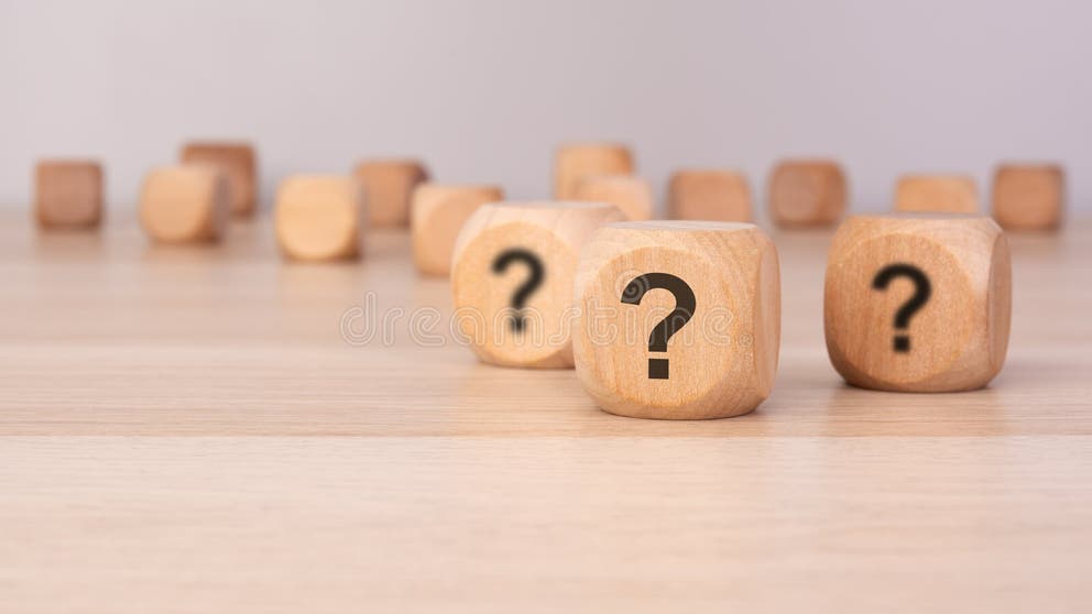 Three Wooden Blocks with Question Marks Over a Gray Background with ...