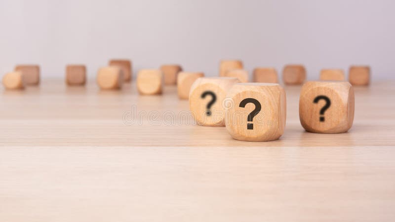 Three Wooden Blocks with Question Marks Over a Gray Background with ...