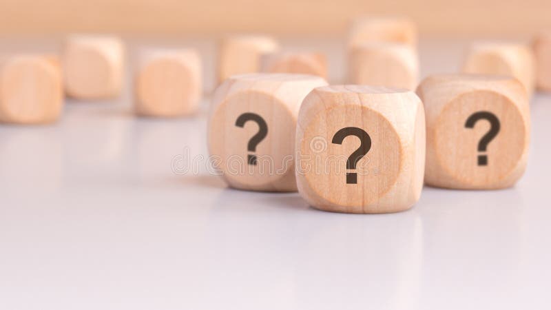 Three Wooden Blocks with Question Marks Over a Gray Background with ...